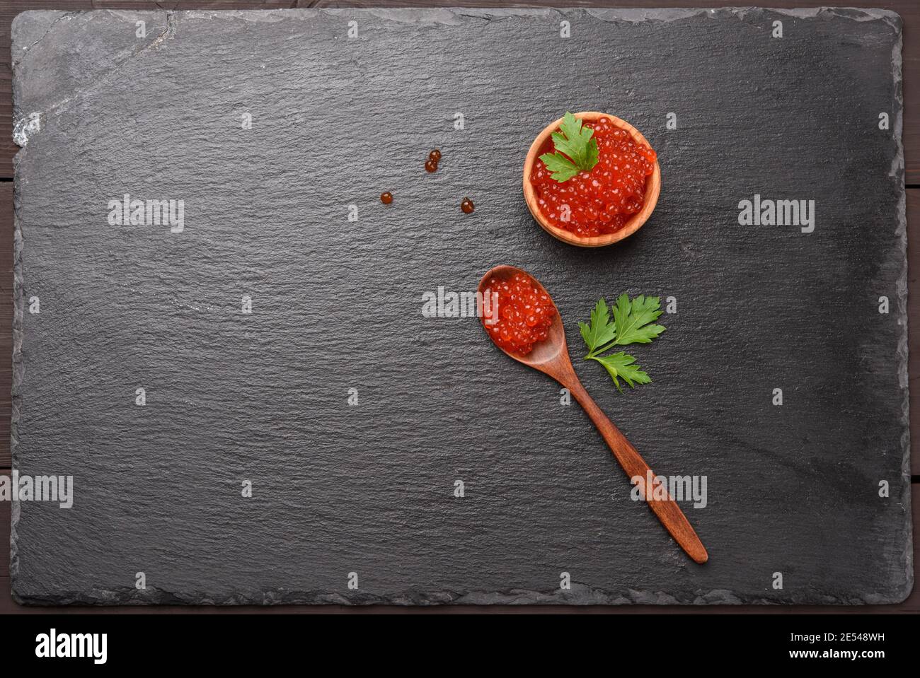 fresh grainy red chum salmon caviar in a wooden spoon, delicious and ...