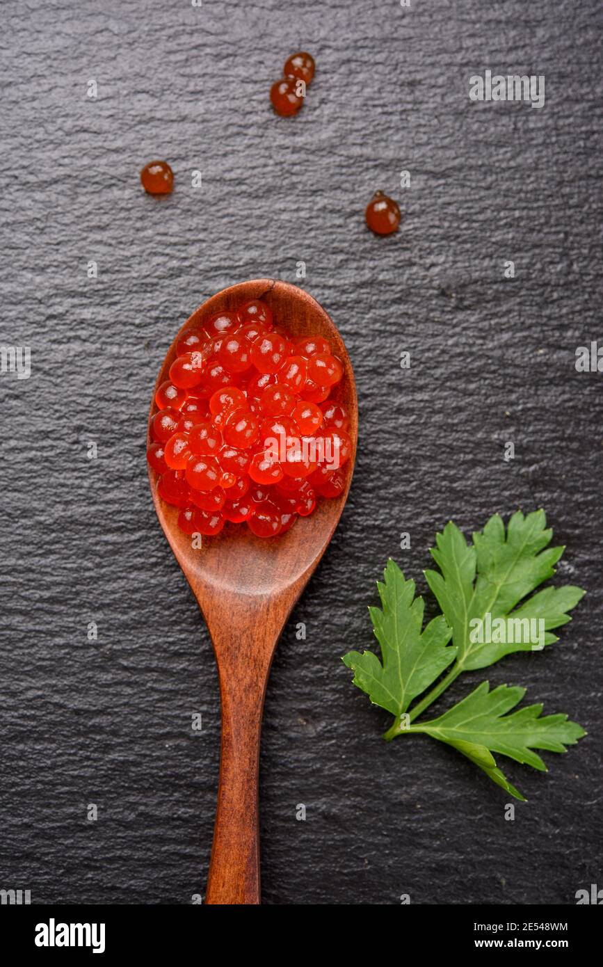 fresh grainy red chum salmon caviar in a wooden spoon, delicious and ...