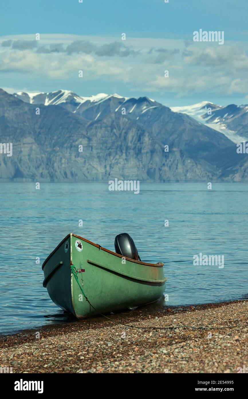 Green Inuit canoe with an engine by the beach in Pond Inlet Stock Photo ...