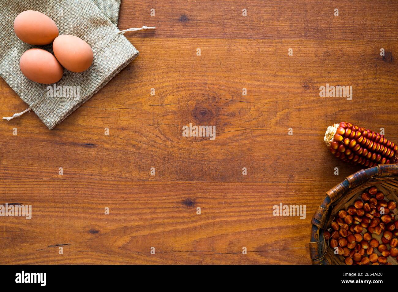 Wooden background with eggs, corn cobs and grains Stock Photo - Alamy