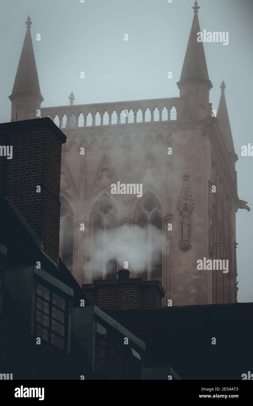 Vertical shot of smoke coming out of a chimney, house in the center of ...
