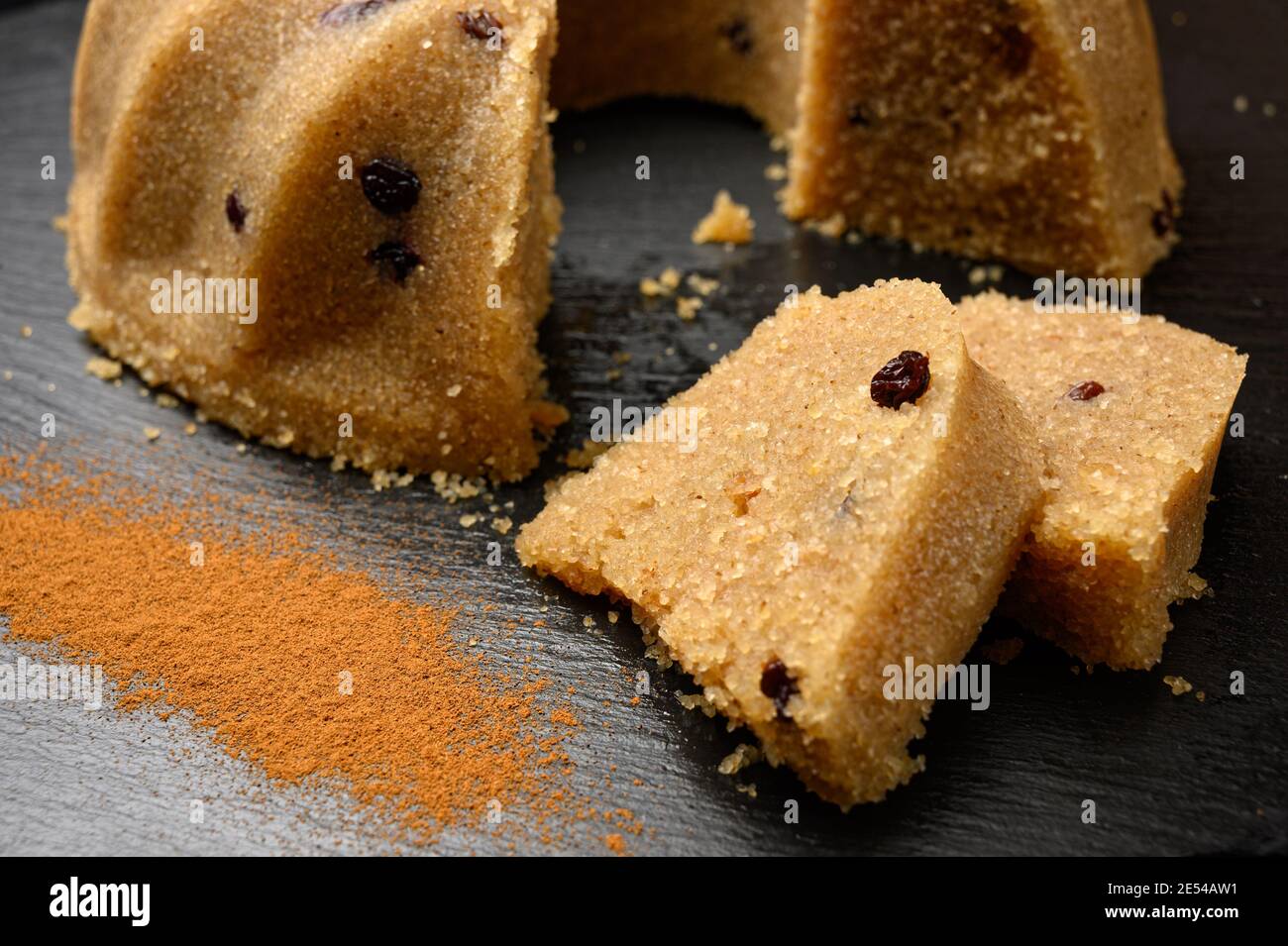 Homemade semolina halva with raisins and cinnamon served on black dish ...