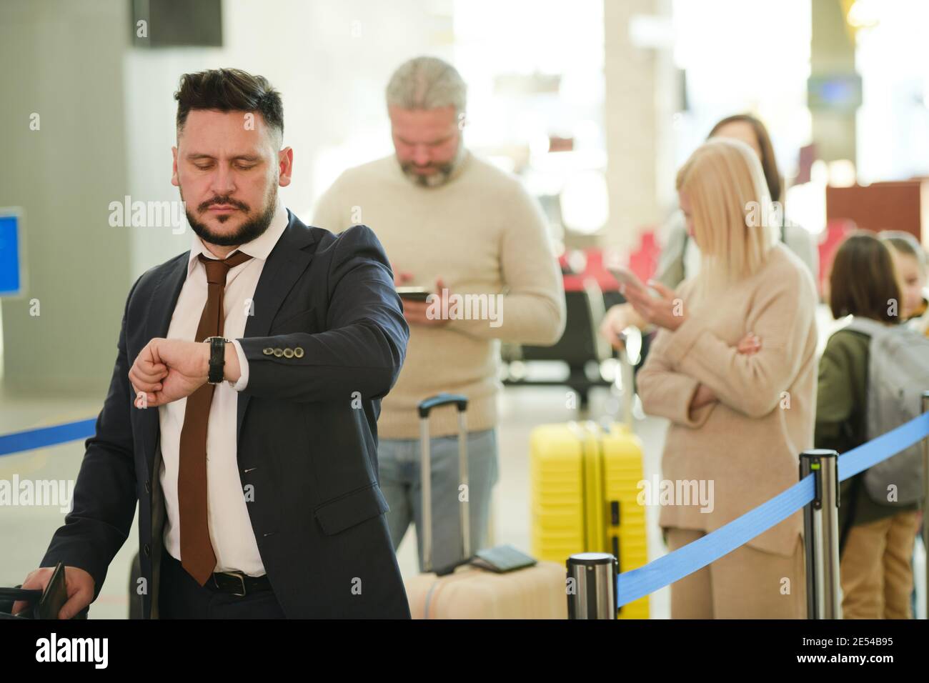 People with luggages queuing for check in at airport Stock Photo - Alamy