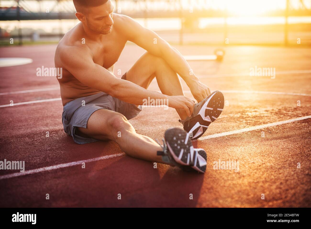 Fitness training outdoors. Handsome man working exercises in early ...