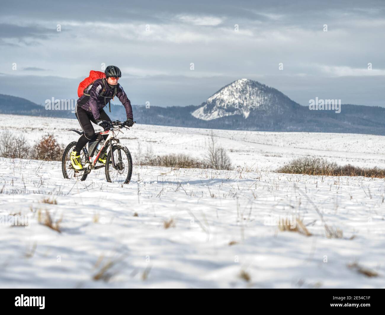 Mountain biker in snowy landscape. Sportsman properly equiped for ...