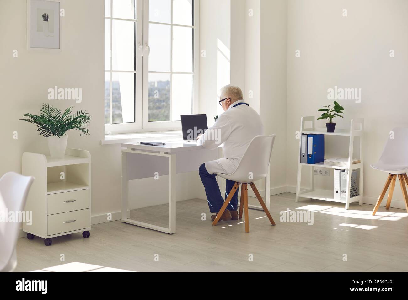 Elderly professional doctor sitting backwards and communicating with ...