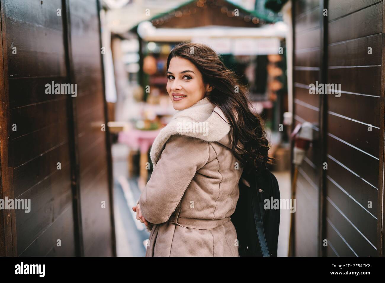 Beautiful young girl in winter coat standing in street passage. Looking ...