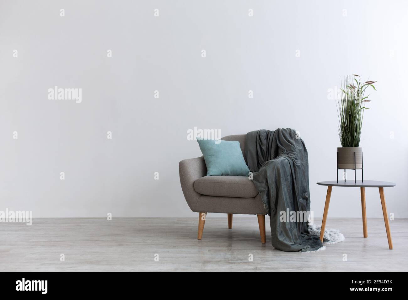 Modern boho cozy corner of home. Gray vintage armchair with blue pillow ...