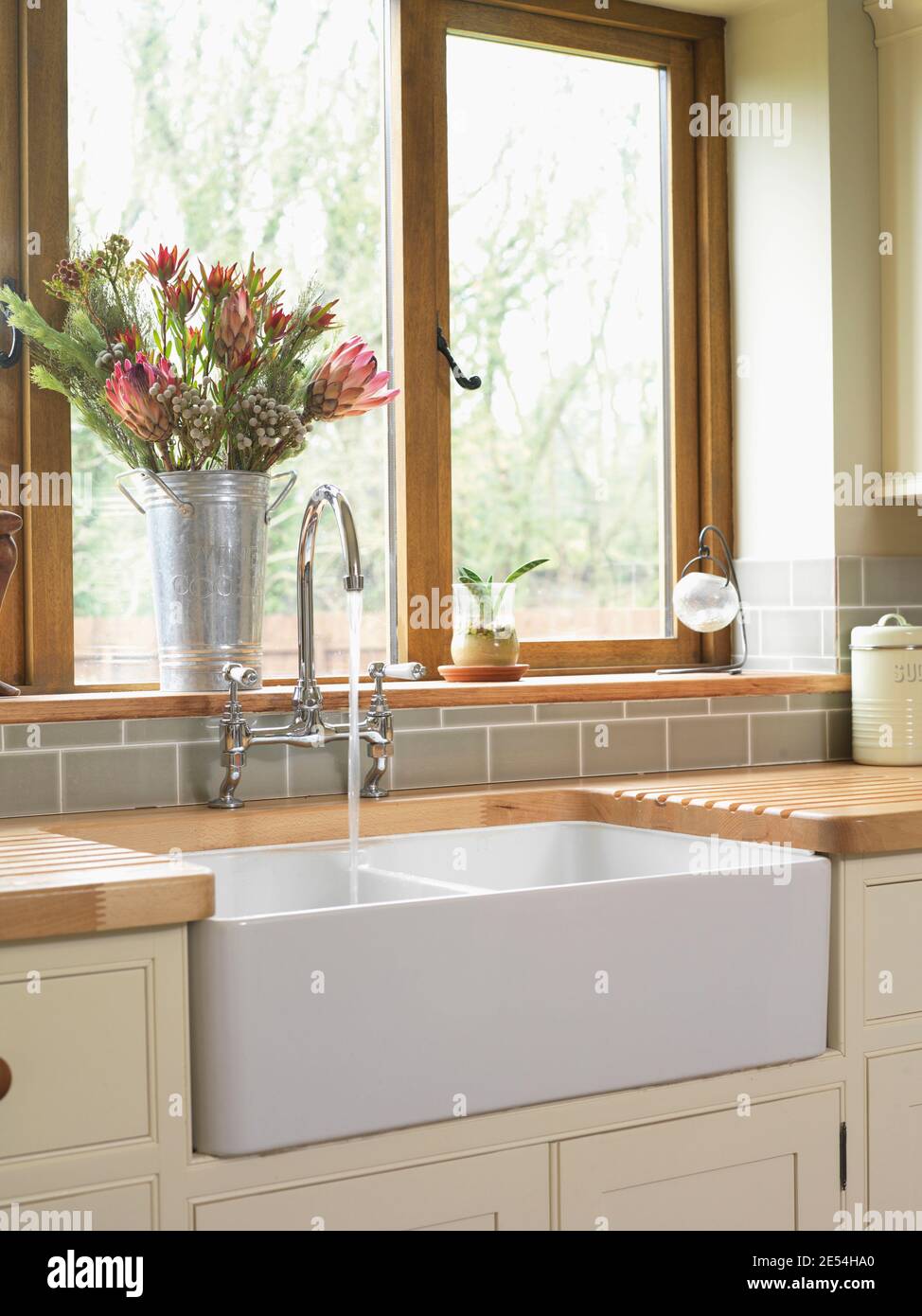 Water running from tap fitting into kitchen sink Stock Photo - Alamy