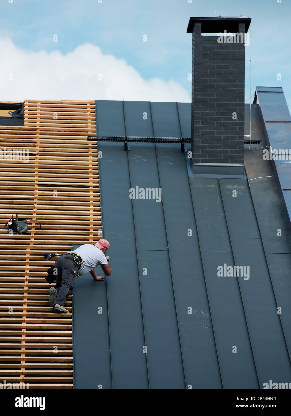 Building crew working on the roof sheeting Stock Photo - Alamy