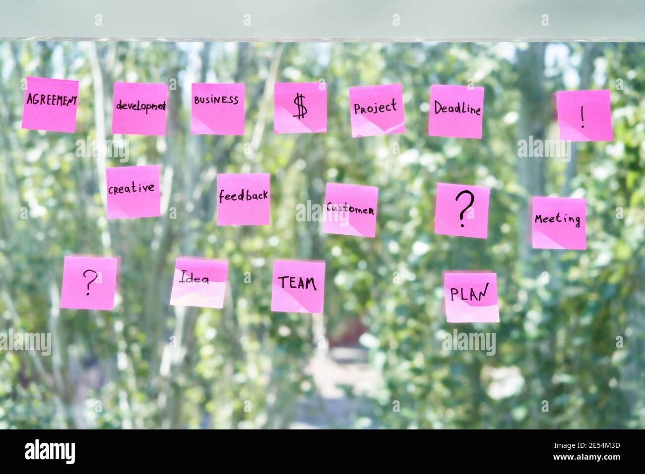 Sticky notes with slogans stuck on the glass in the office ...