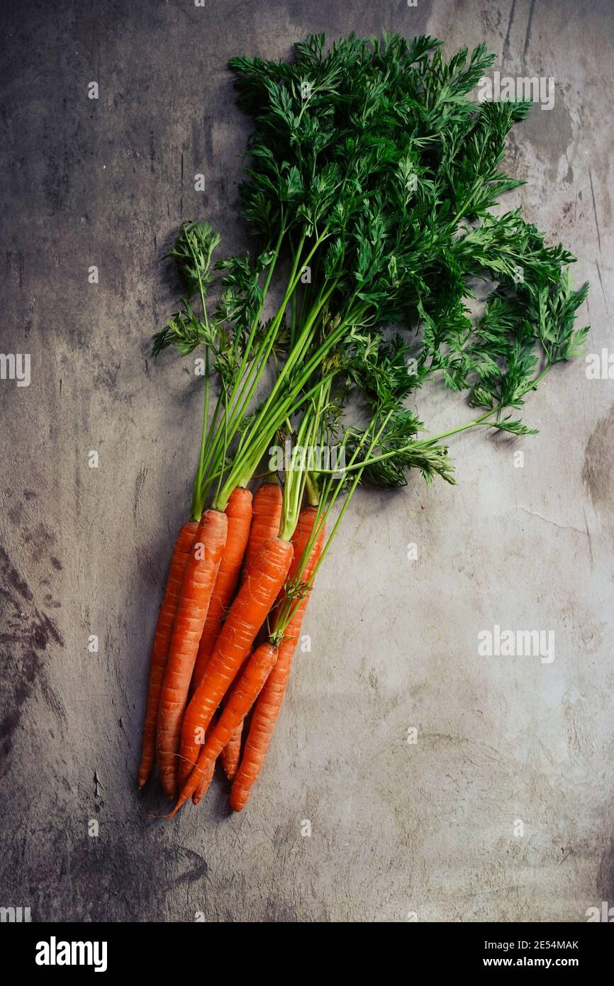 Fresh carrots with leaves on, top down view Stock Photo - Alamy