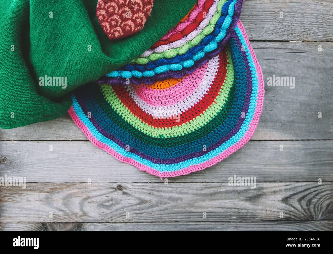 Knitted mat and covers on wooden background. Natural interior elements ...