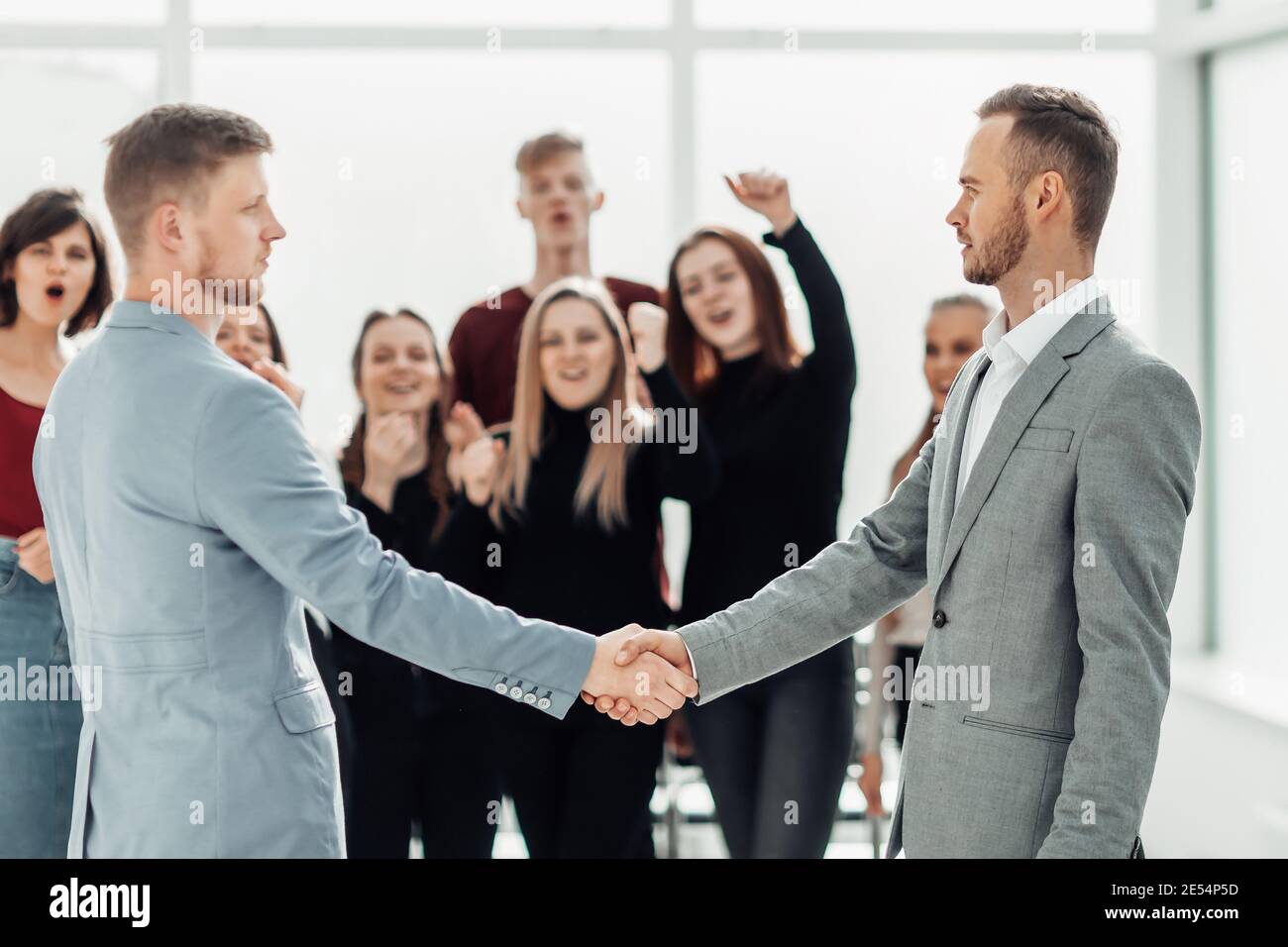 serious young men shaking hands. concept of cooperation Stock Photo - Alamy