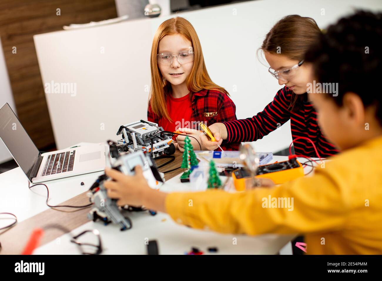 Group of happy kids programming electric toys and robots at robotics ...