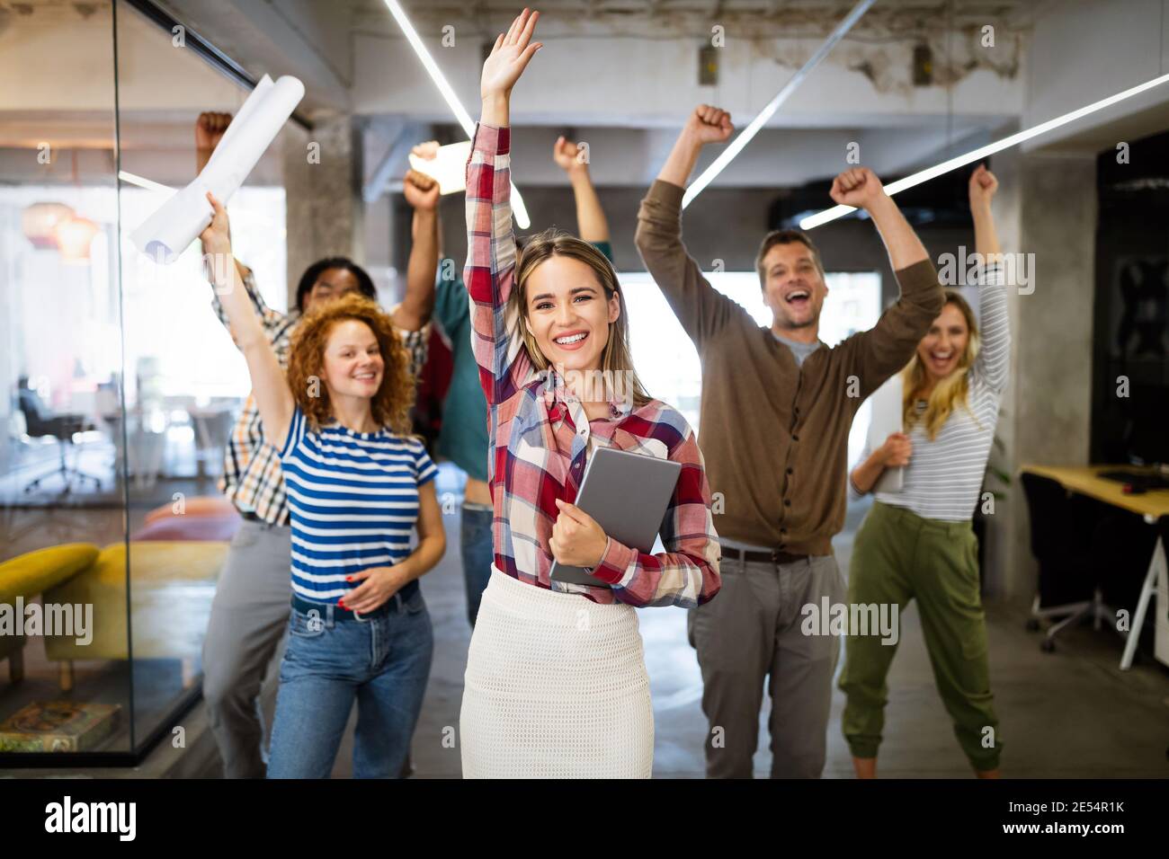 Happy business people celebrating success at company Stock Photo - Alamy