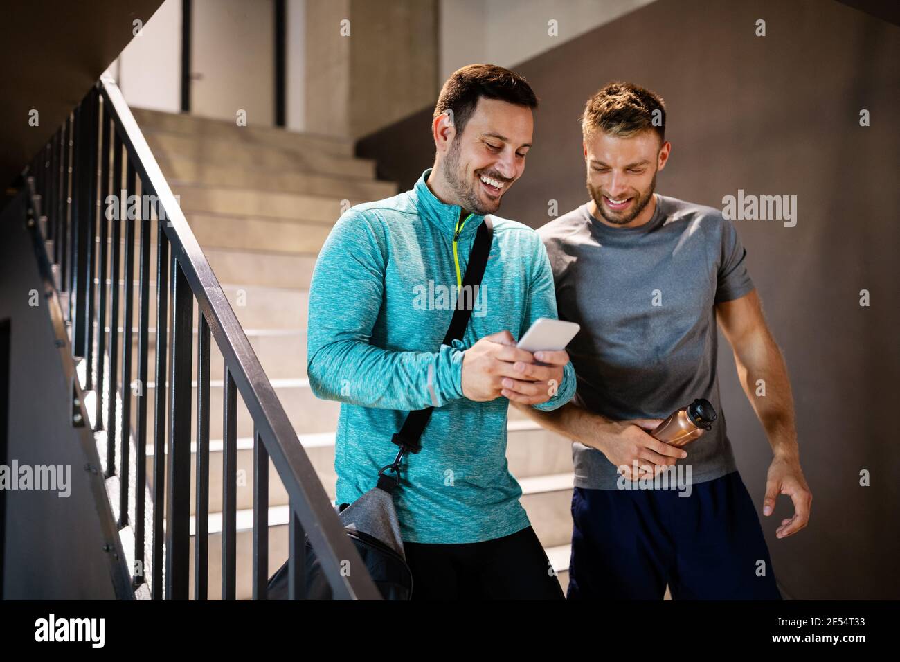 Handsome fit men friends talking, smiling after workout in gym Stock ...