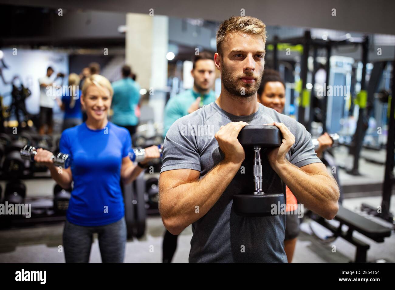 Attractive sports people friends are working out in gym Stock Photo - Alamy