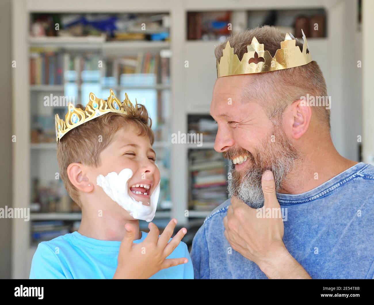 Father and son put the crown on their heads and have fun. Father has a ...
