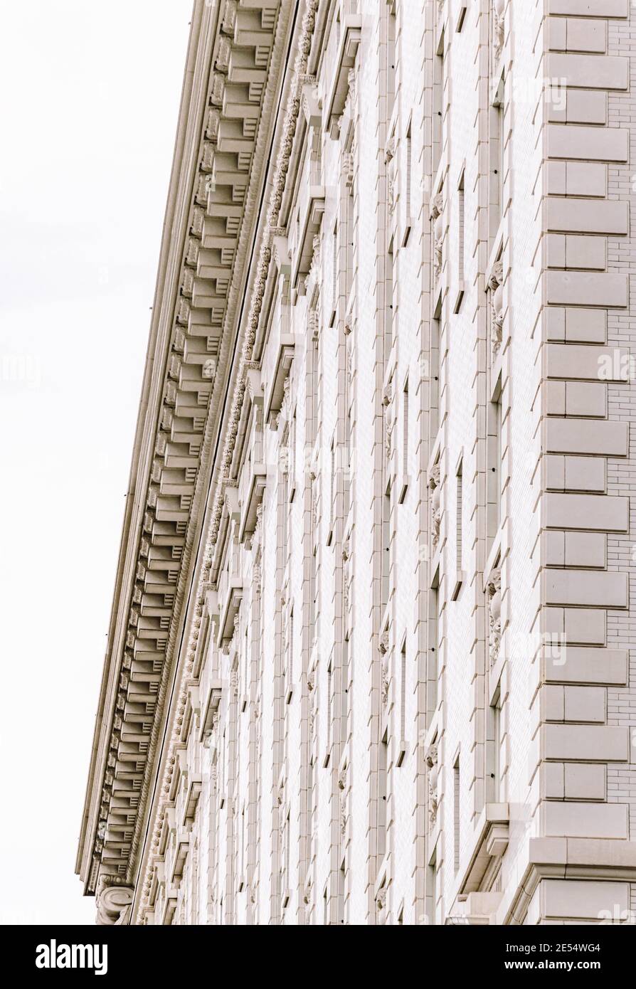 Vertical low angle of a brick wall building on white sky background ...