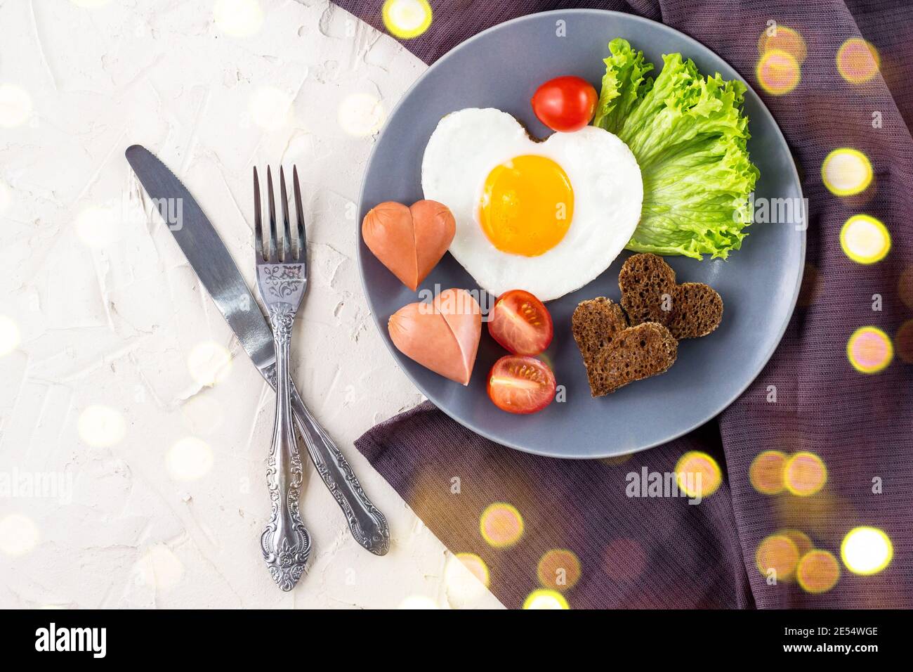 Valentines day breakfast with heart shaped fried eggs served on grey plate. flat lay, top view ...