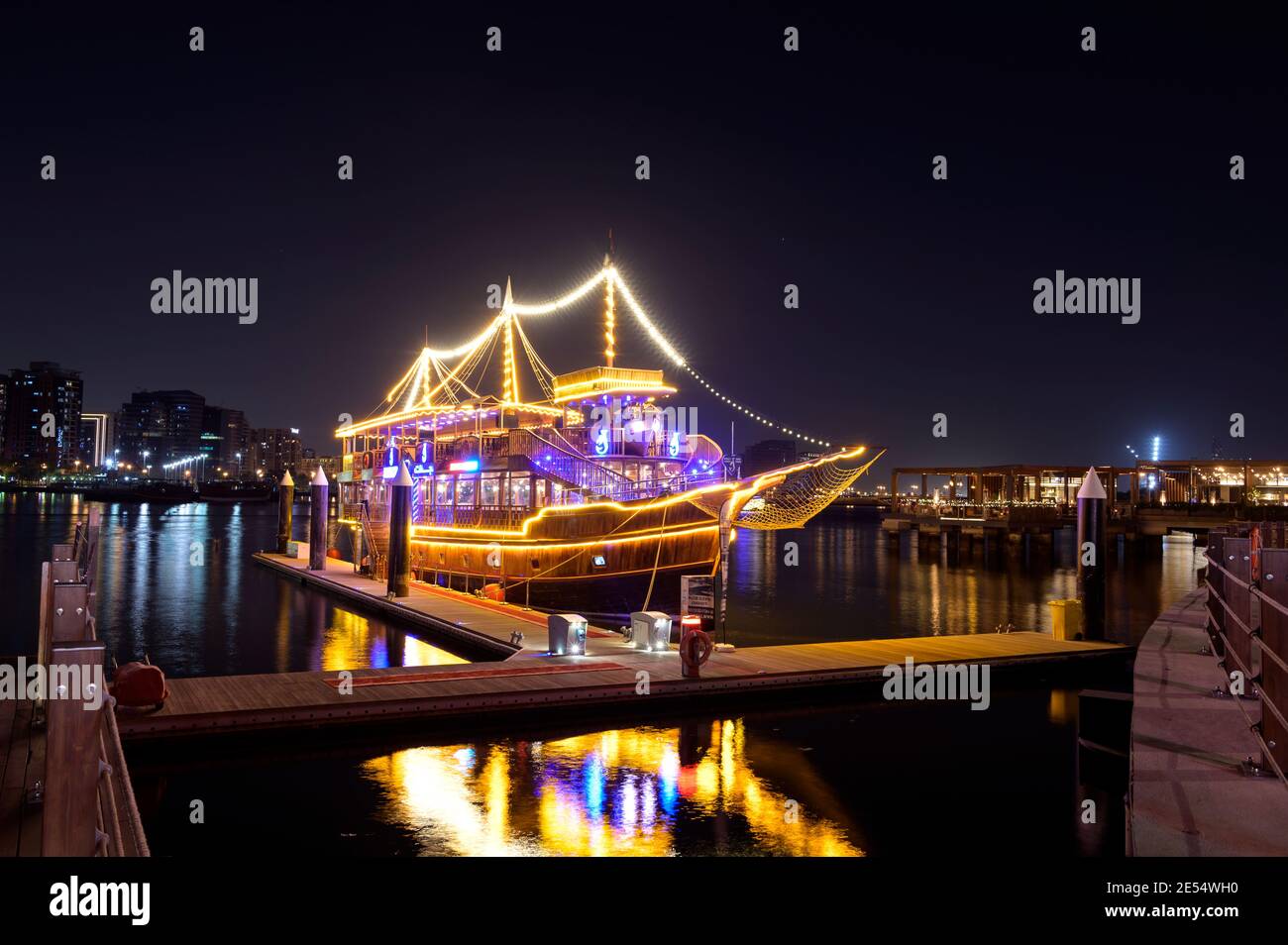 Beautifully illuminated Dhow cruise dinner ship showing reflections on ...