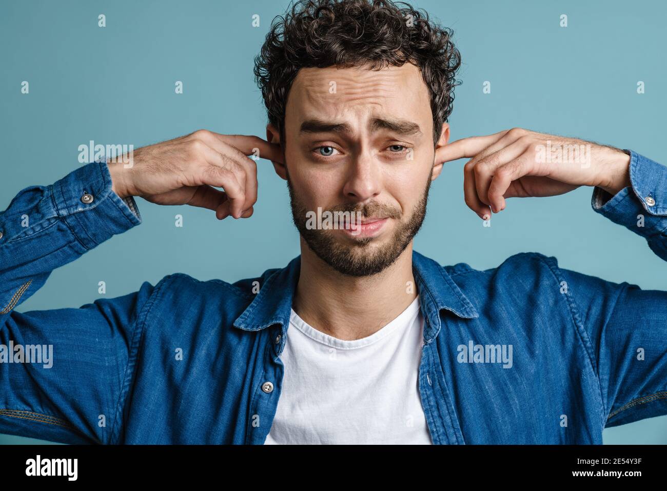Unhappy man plugging ears hi-res stock photography and images - Alamy