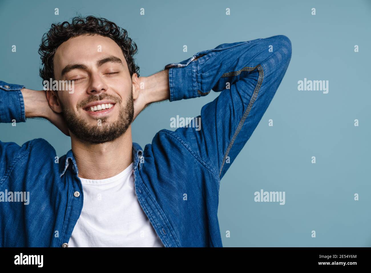 Happy handsome guy posing with hands clasped behind his neck isolated ...