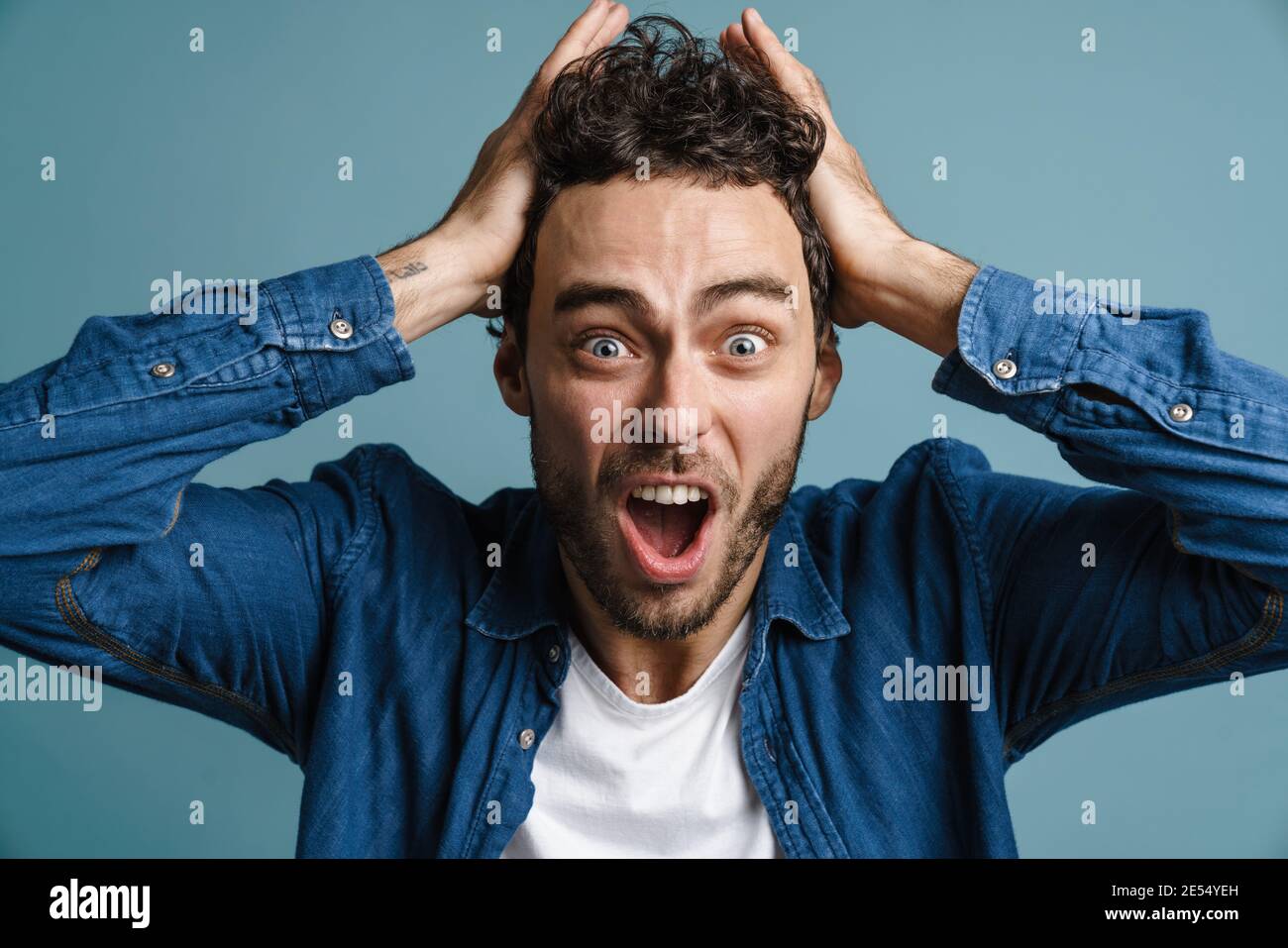 Shocked caucasian guy screaming and grabbing his head isolated over ...