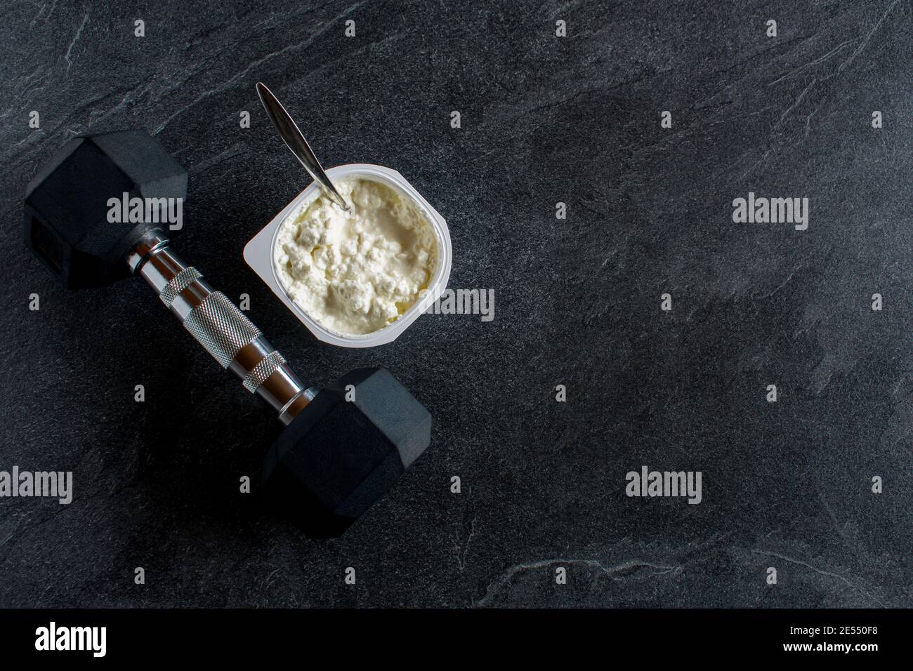 dumbbell with protein food on dark table background with copy space ...