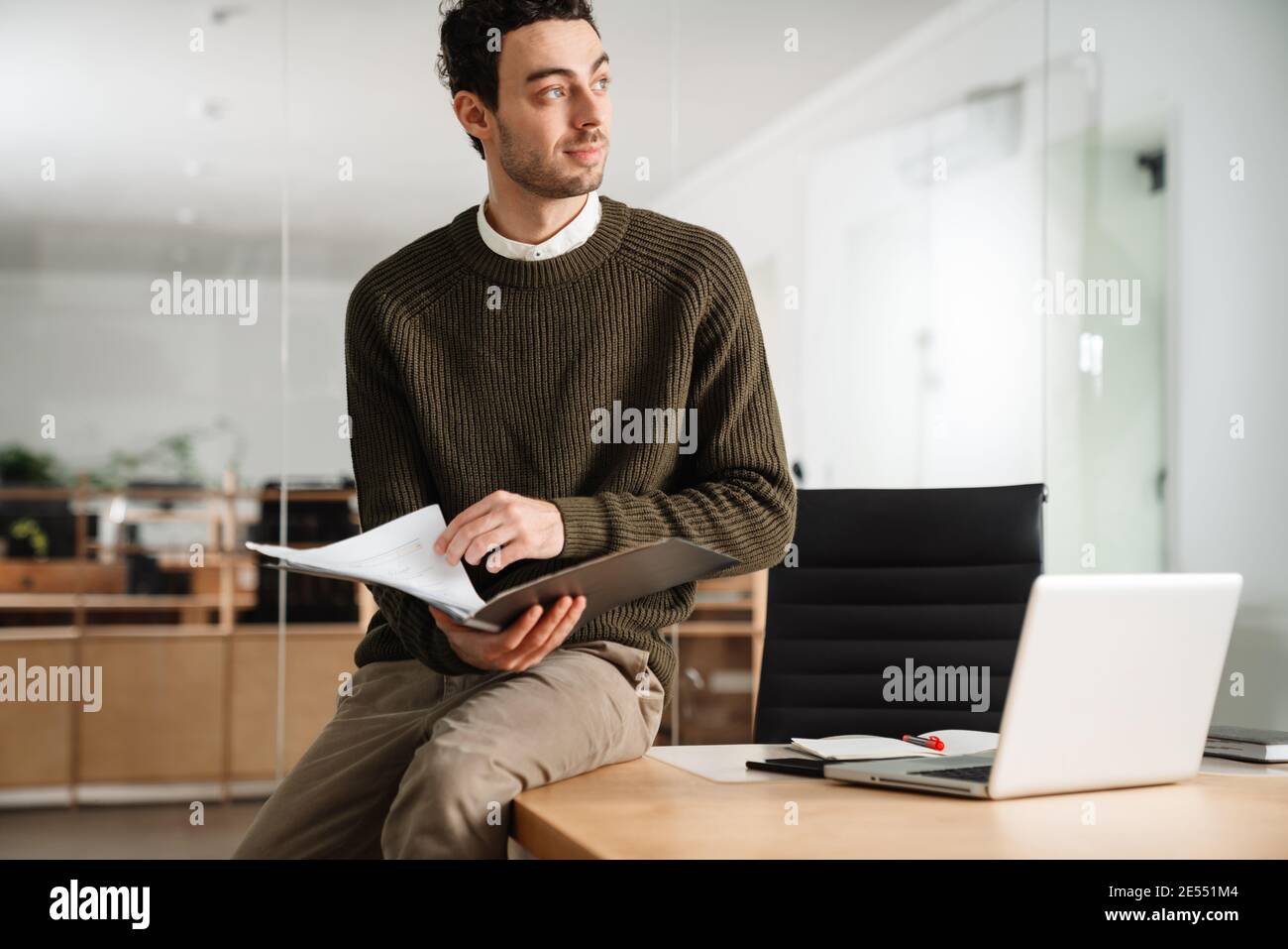 Confident young manager working at the office, holding documents Stock ...