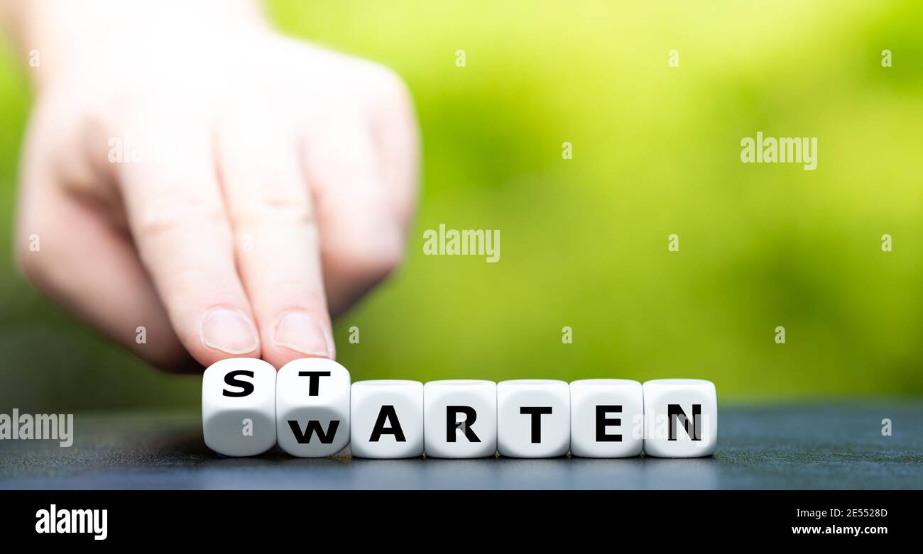 Hand turns dice and changes the German word "warten" (wait) to "starten ...
