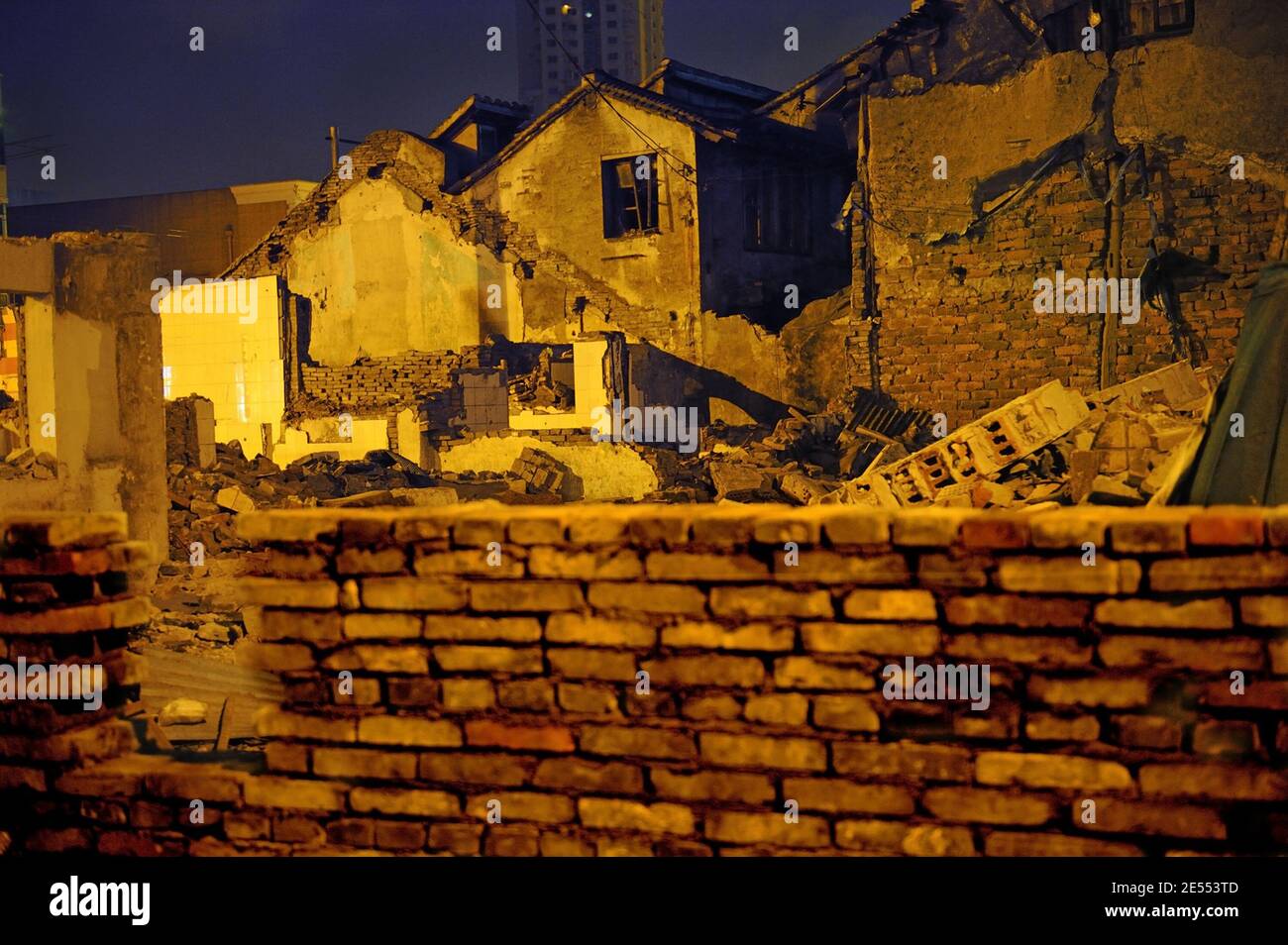 Detroyed building, rubble in front of old houses. Night time Stock ...