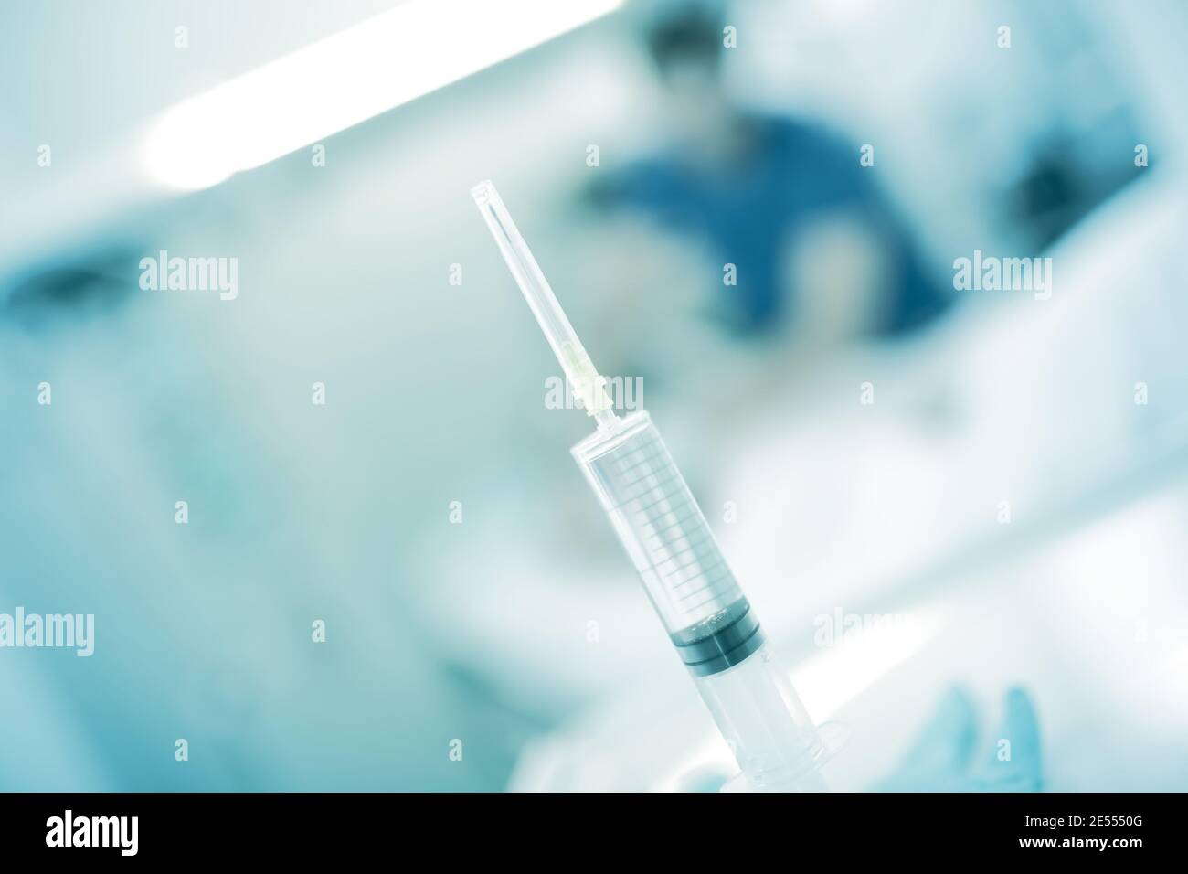 Full syringe on the background of working medical person Stock Photo ...