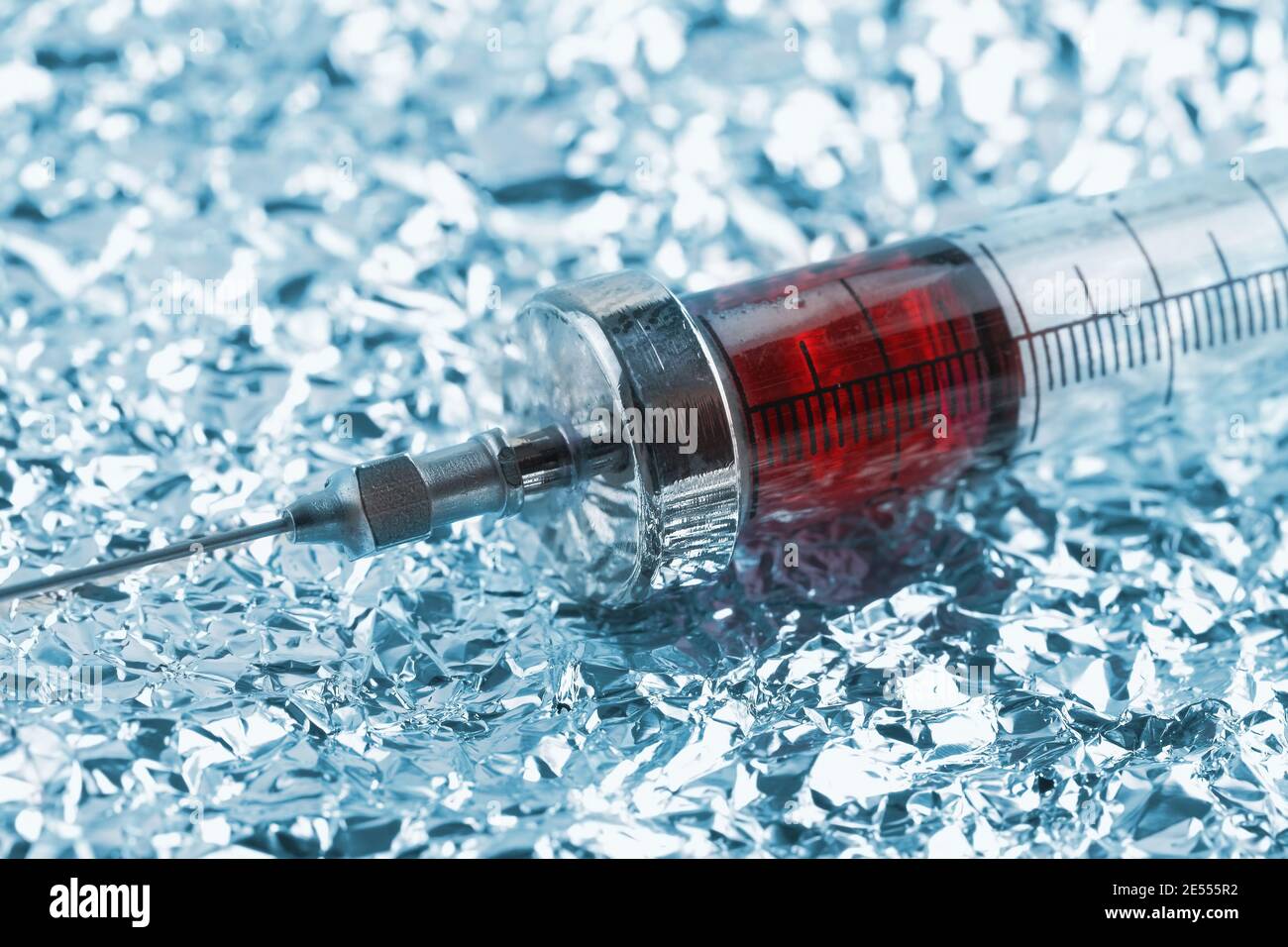 Old filled syringe on the crumpled metallic paper Stock Photo - Alamy