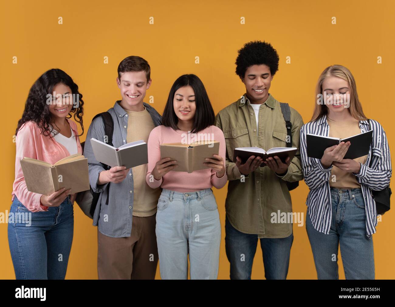 Happy young university students studying with books in library Stock ...