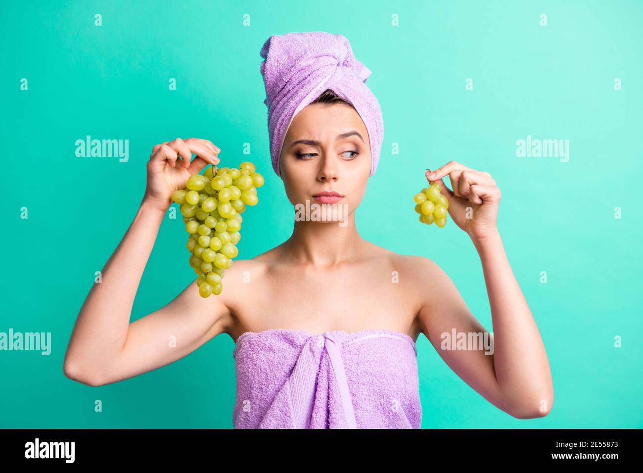 Photo of pretty lady hold look grape bunch wear violet towel turban ...