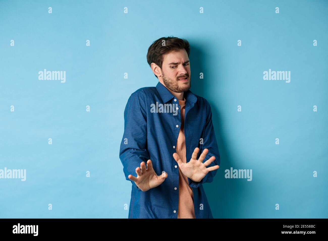 Image of man cringe and look at something disgusting, step back from ...