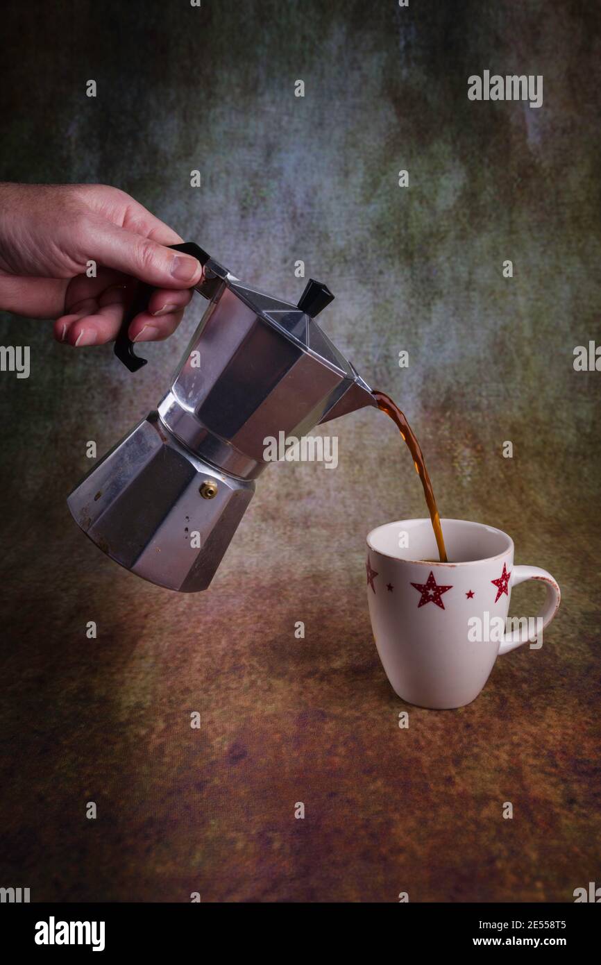 Pouring coffee into a mug from an old, dirty coffee percolator Stock ...