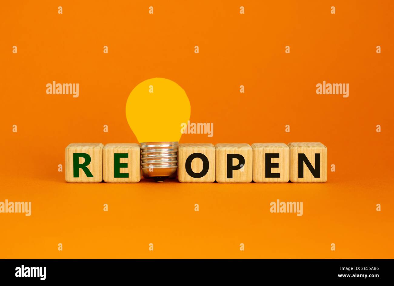 Reopen symbol. Wooden cubes with word 'reopen'. Yellow light bulb ...