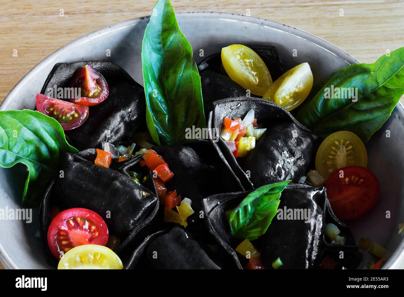 Black ravioli pasta with tomato and basil Stock Photo - Alamy
