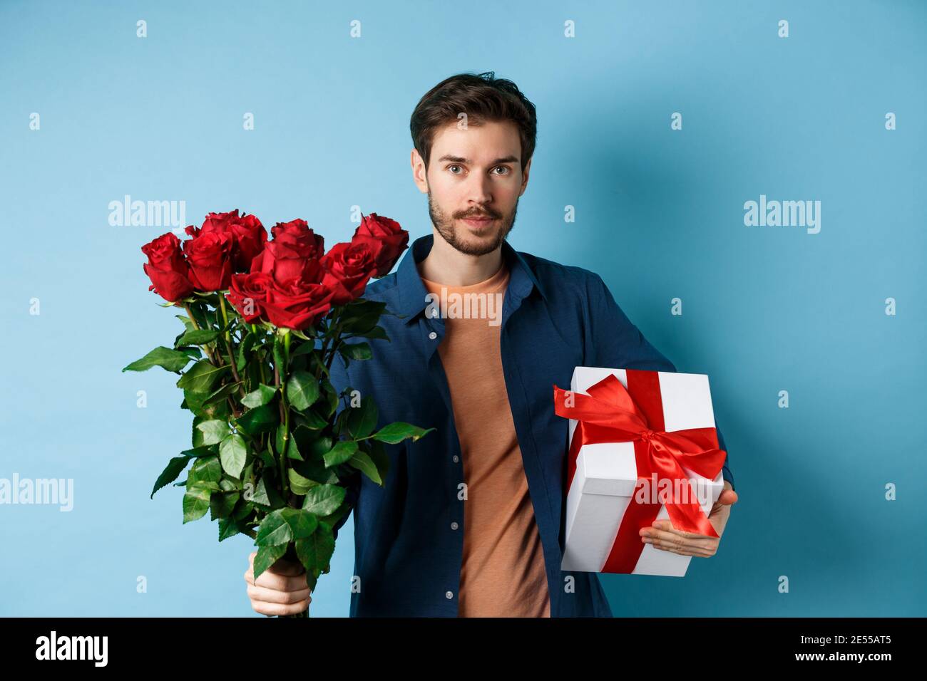 Romance and valentines day. Man presenting bouquet of red roses to ...