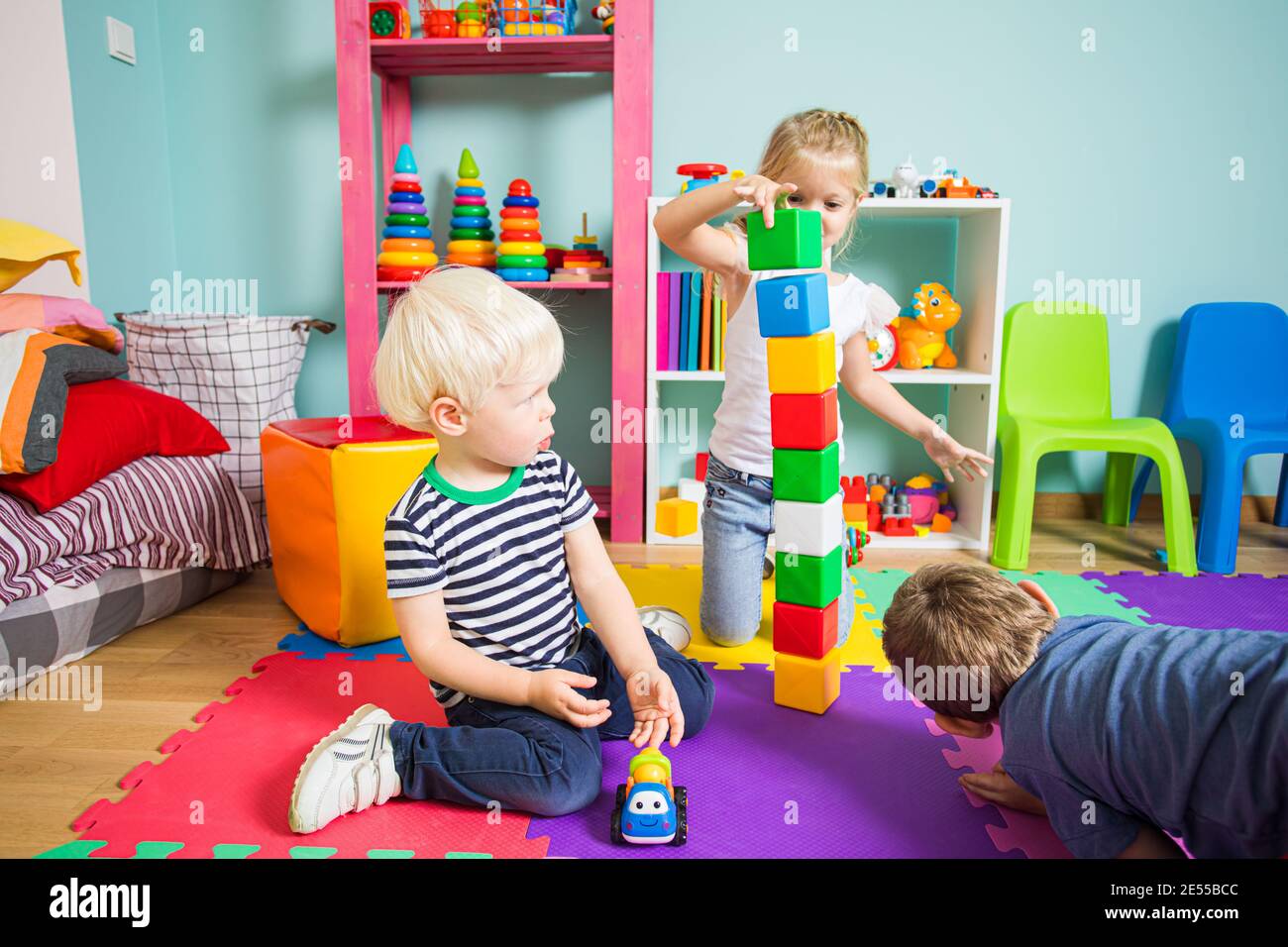 Kids playing together on a colorful mats Stock Photo - Alamy