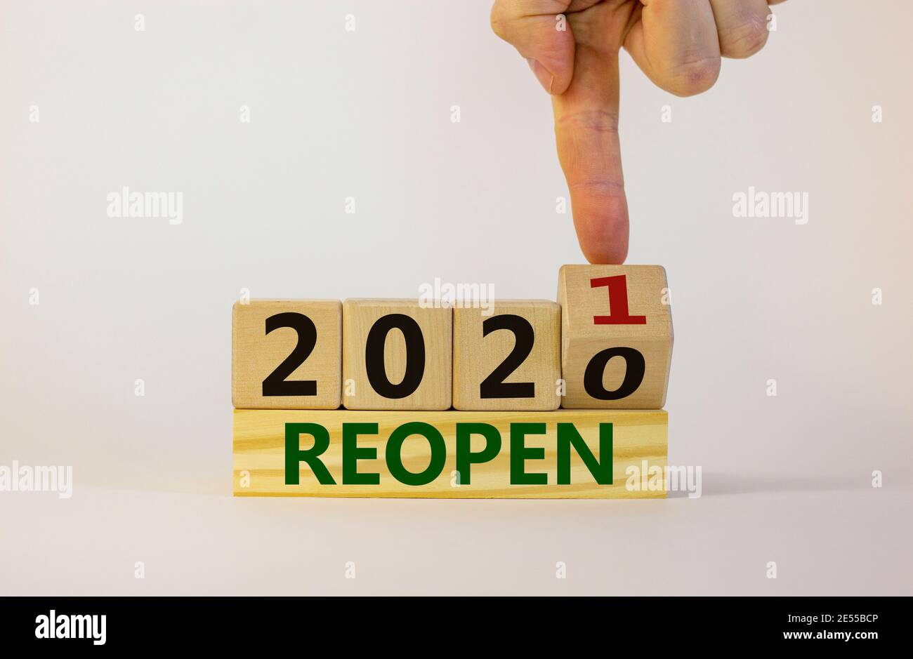 Business concept of new year 2021 reopen. Businessman flips a wooden ...