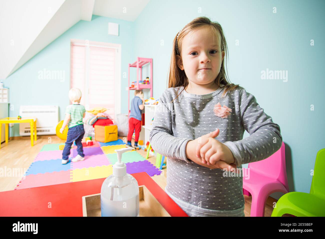 the little girl kills germs to use antibacterial gel Stock Photo - Alamy