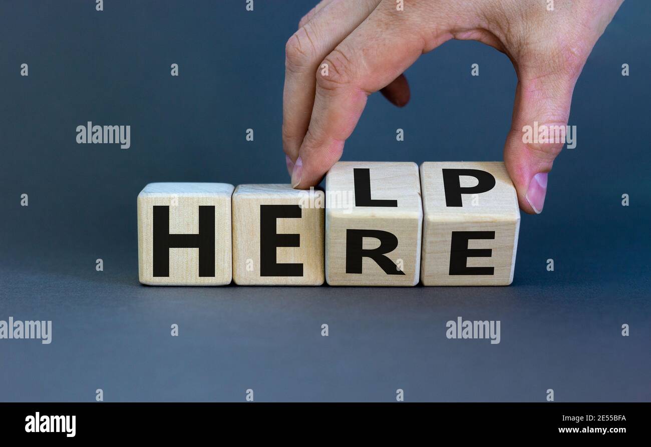 Help is here symbol. Businessman turns cubes and changes the word help ...