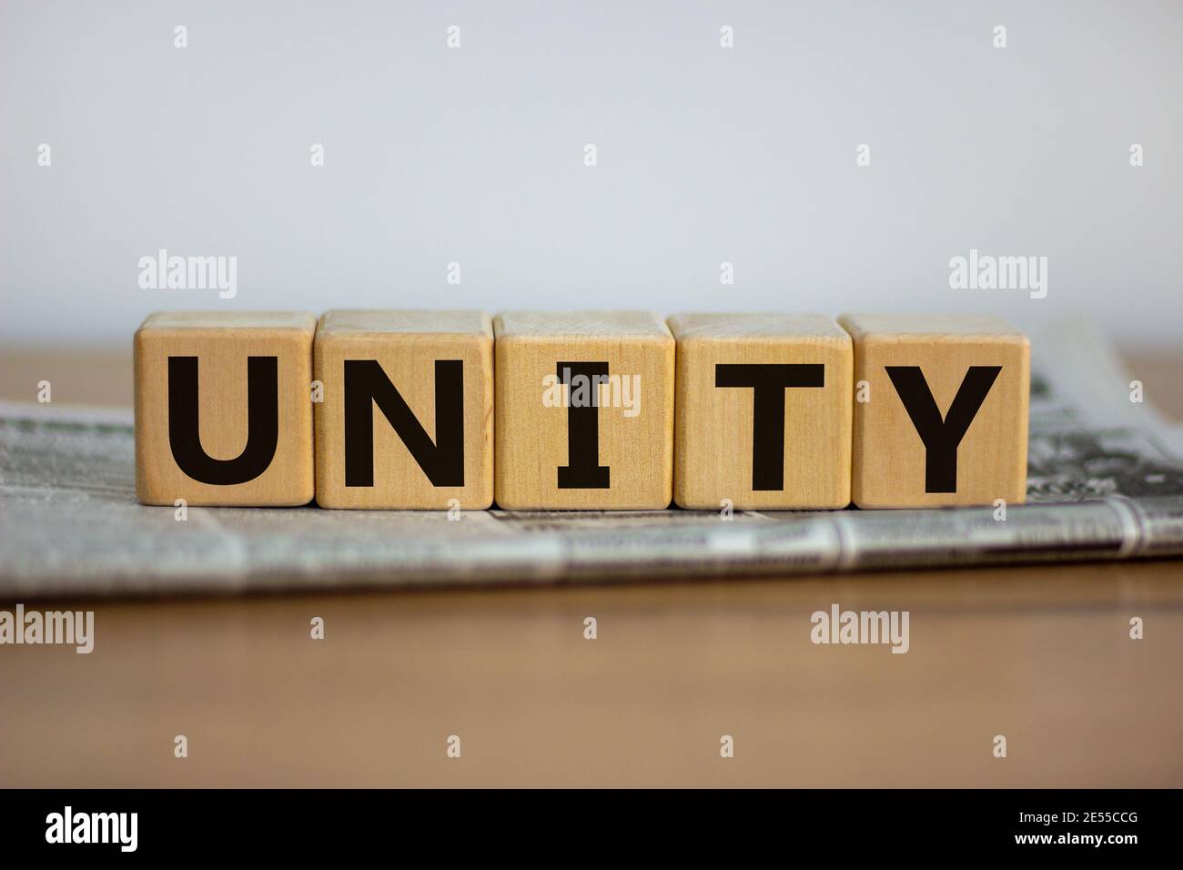 Time to unity symbol. Wooden cubes placed on a newspaper. The word ...