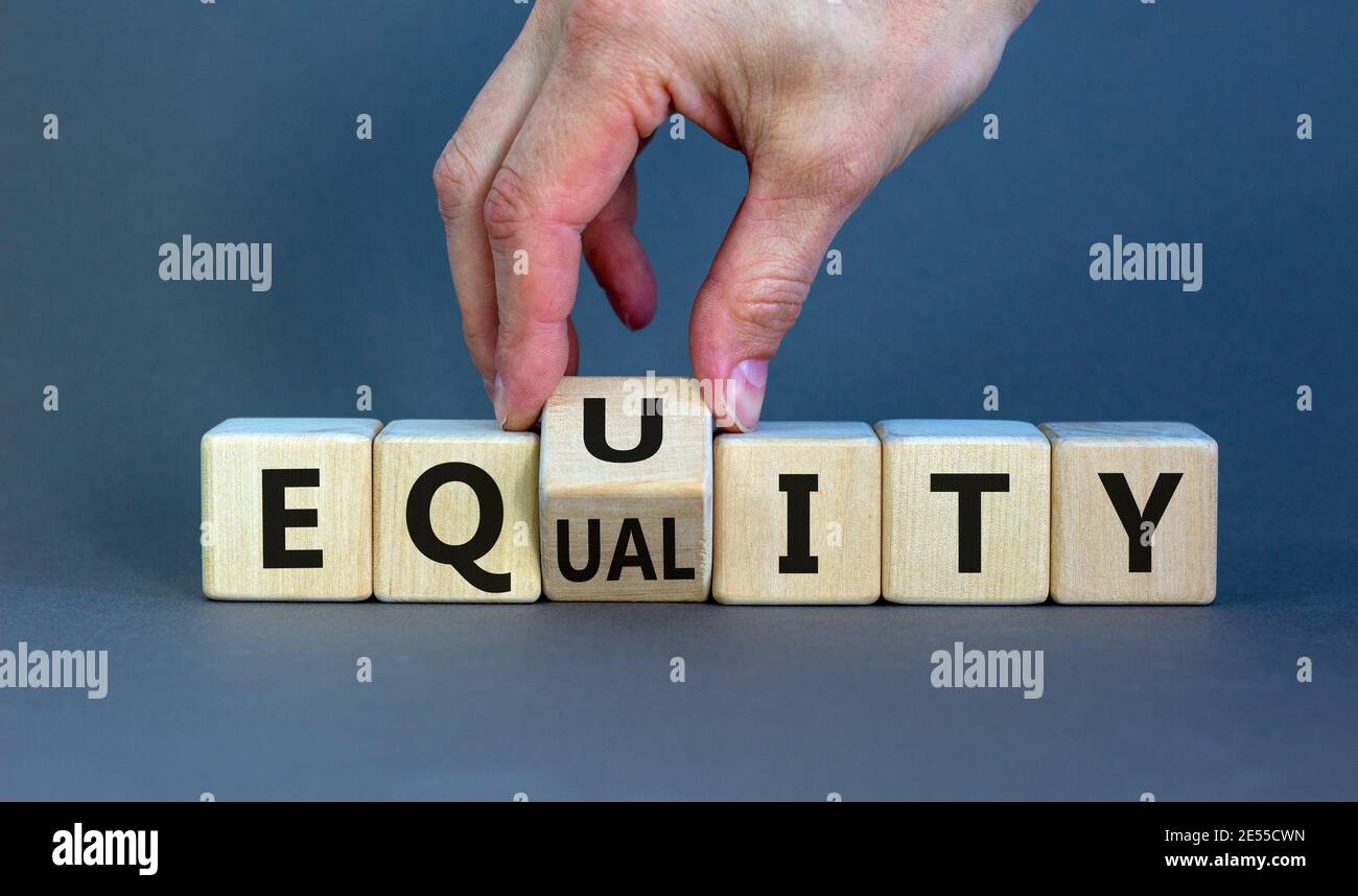 Equality or equity symbol. Businessman turns a cube and changs the word ...