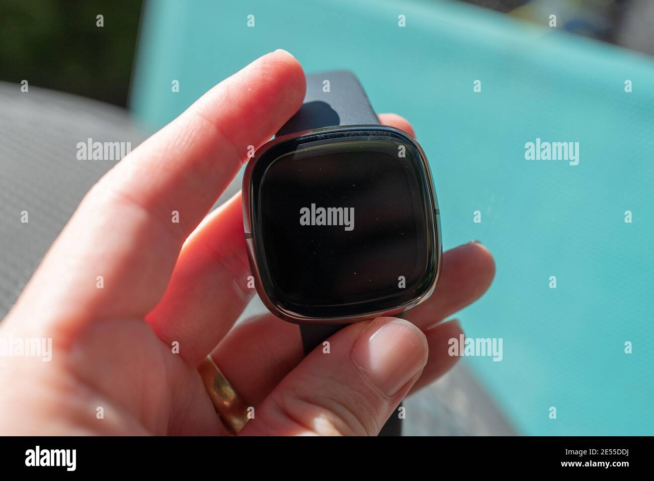 Human hand holding watch face on Fitbit Sense health tracking smart ...