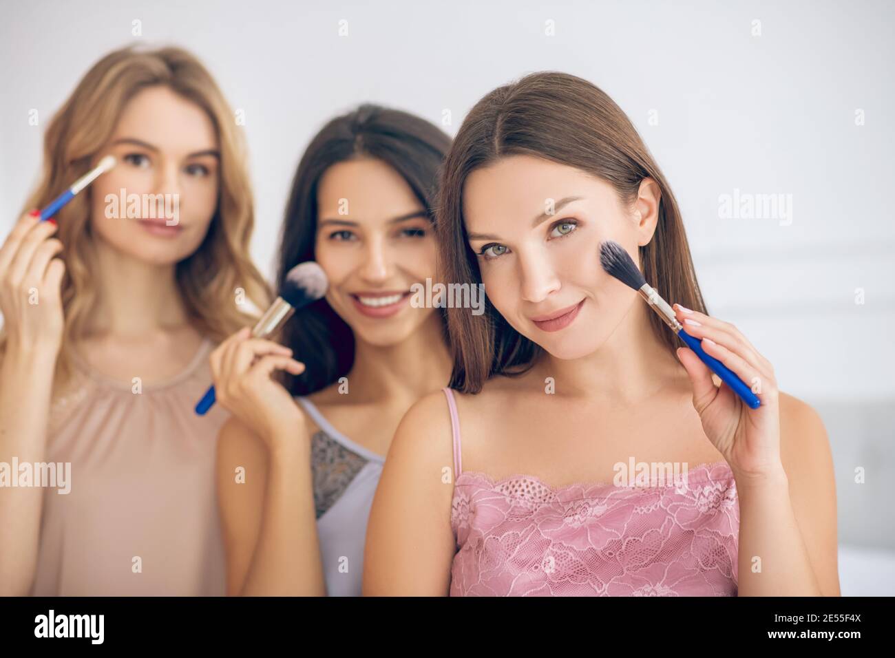Pretty girls doing make up and looking happy Stock Photo - Alamy